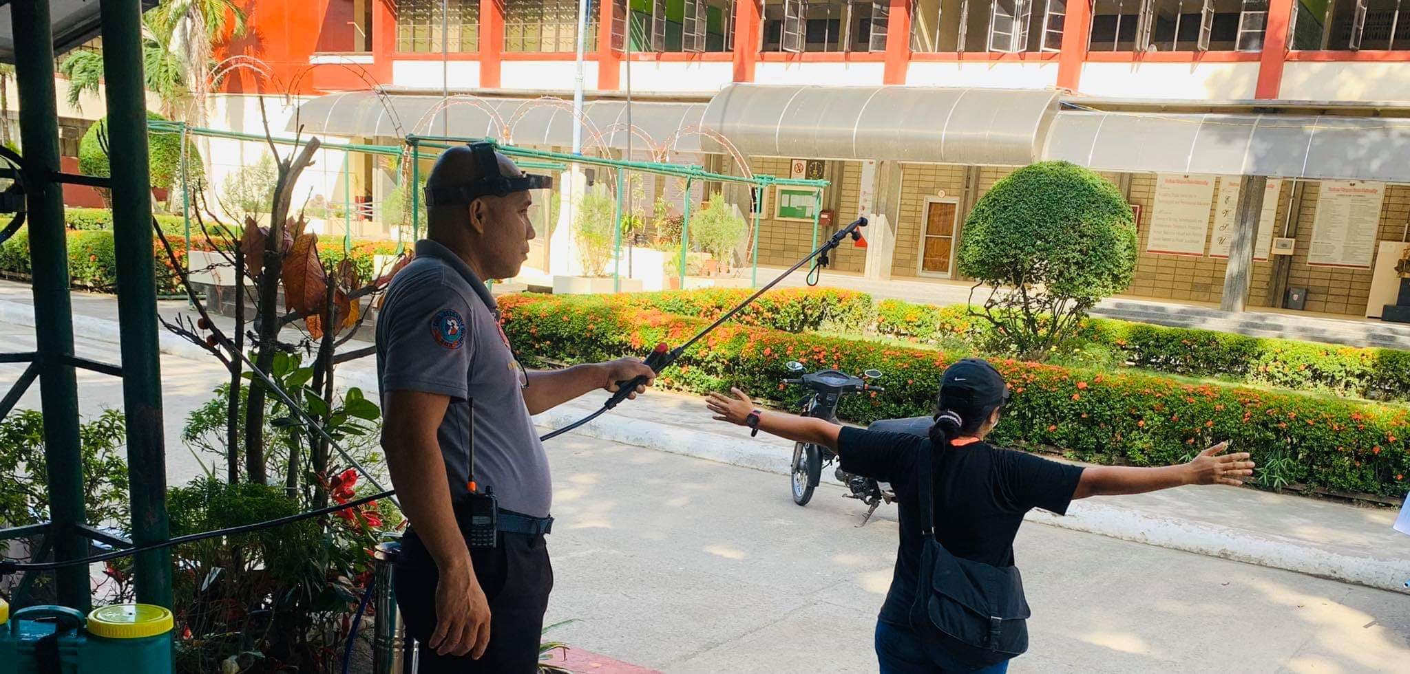 Entrants of EVSU Tacloban campus pass through a disinfectant spray ...